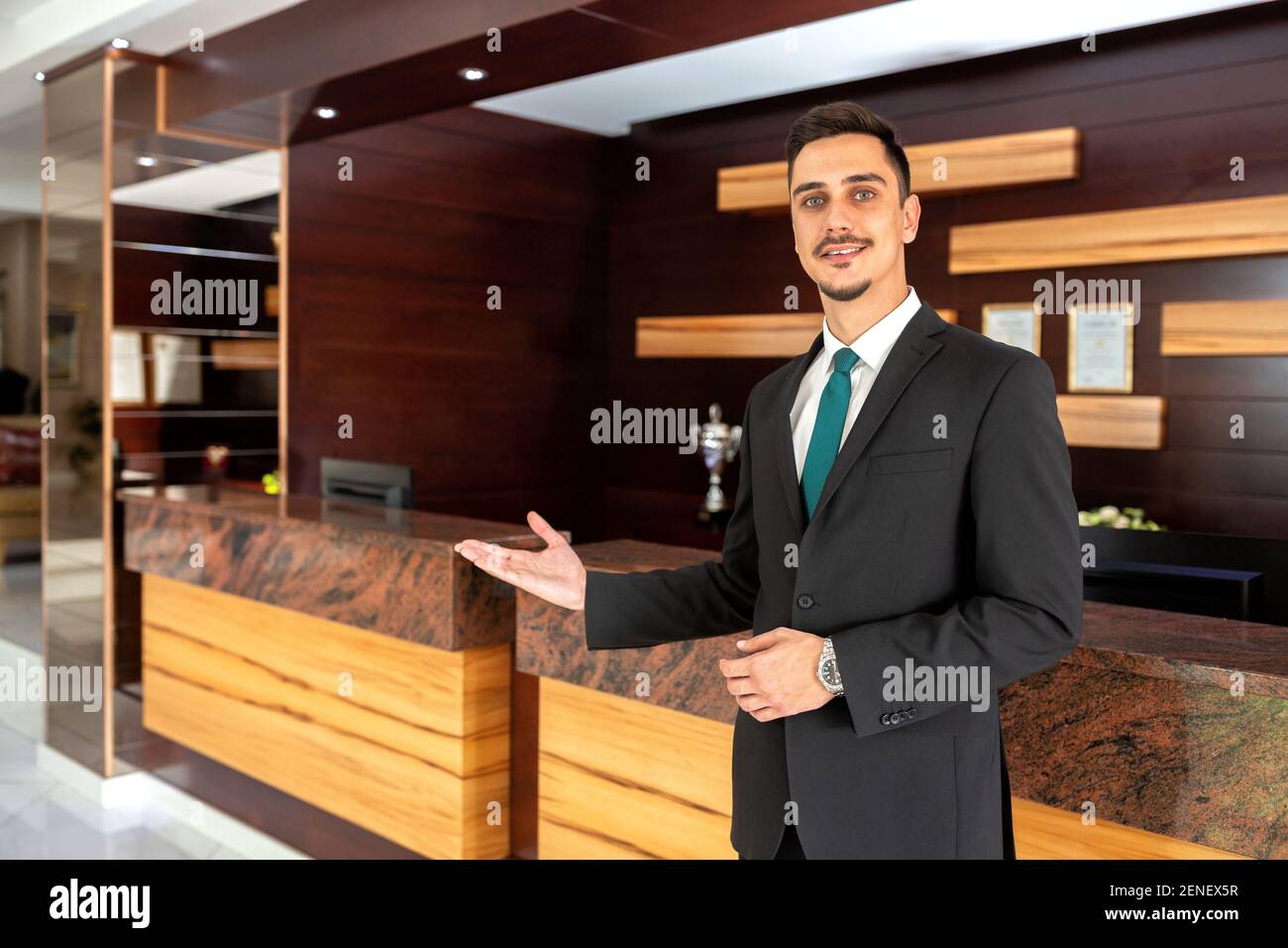Receptionist dressed in fancy suit standing and welcoming guests Stock ...