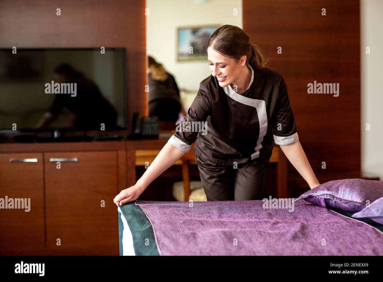 Room service preparing the guest rooms by getting bed sheets in order ...