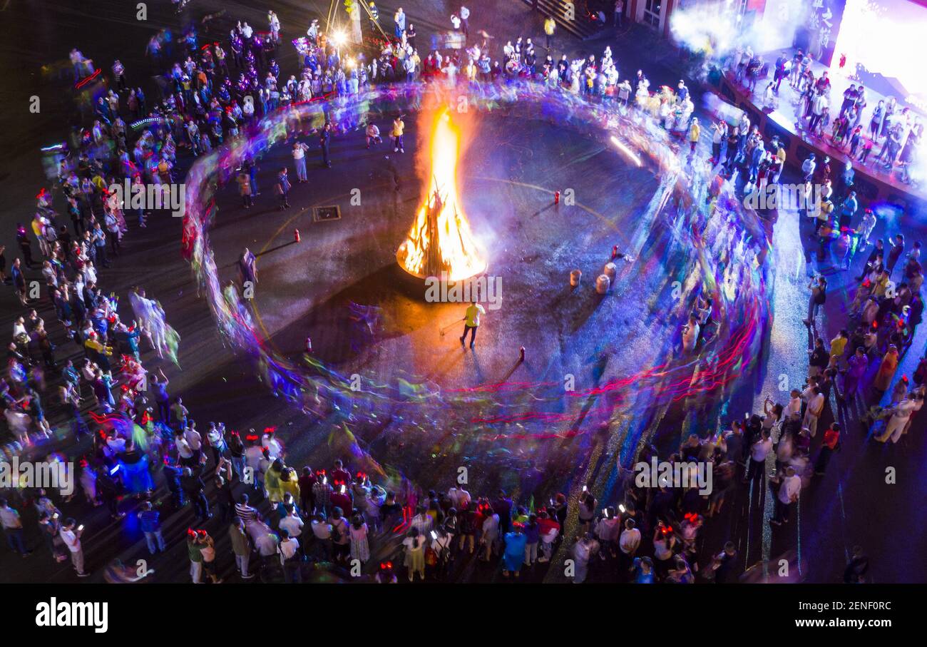 Local residents and tourists gather at a bonfire party during a music ...