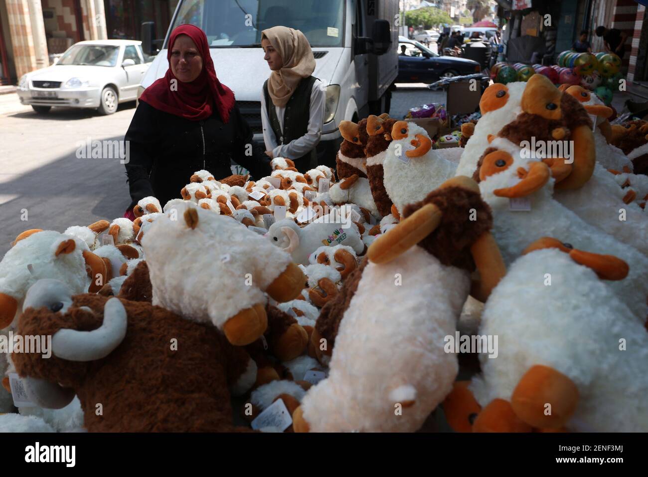 Palestinians shop at a market ahead of the Eid al-Adha festival, in ...