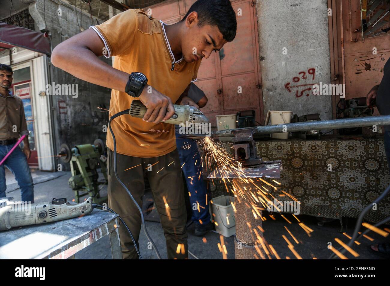 A Palestinian blacksmiths sharpen various tools and knives to be used ...