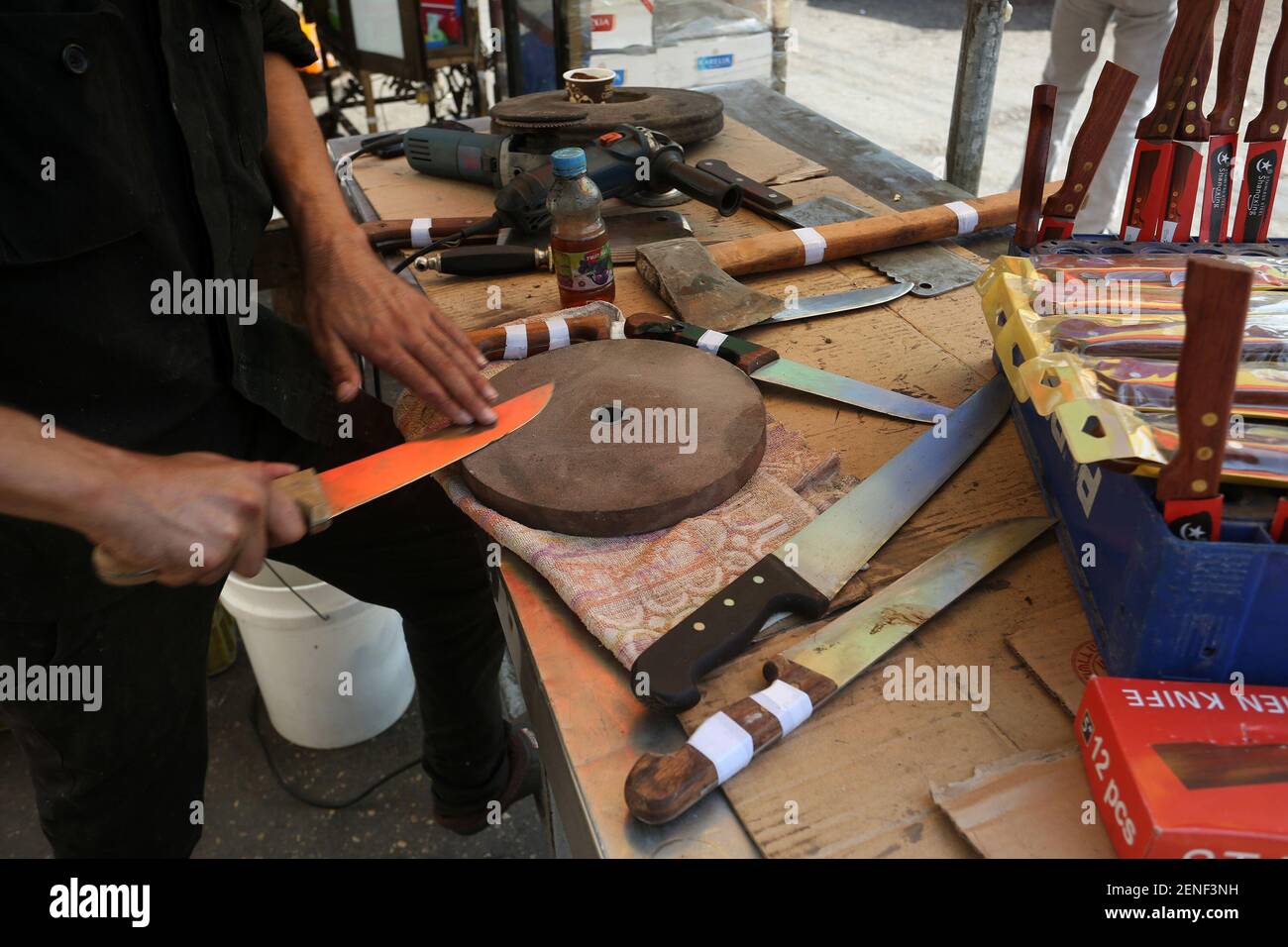 A Palestinian blacksmiths sharpen various tools and knives to be used ...