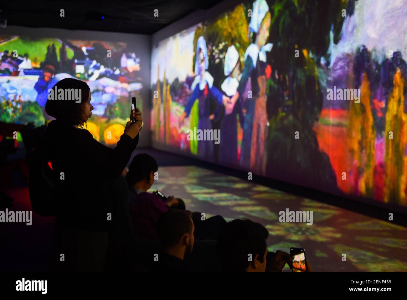 A Visitor takes pictures of a multimedia projection in one of the ...