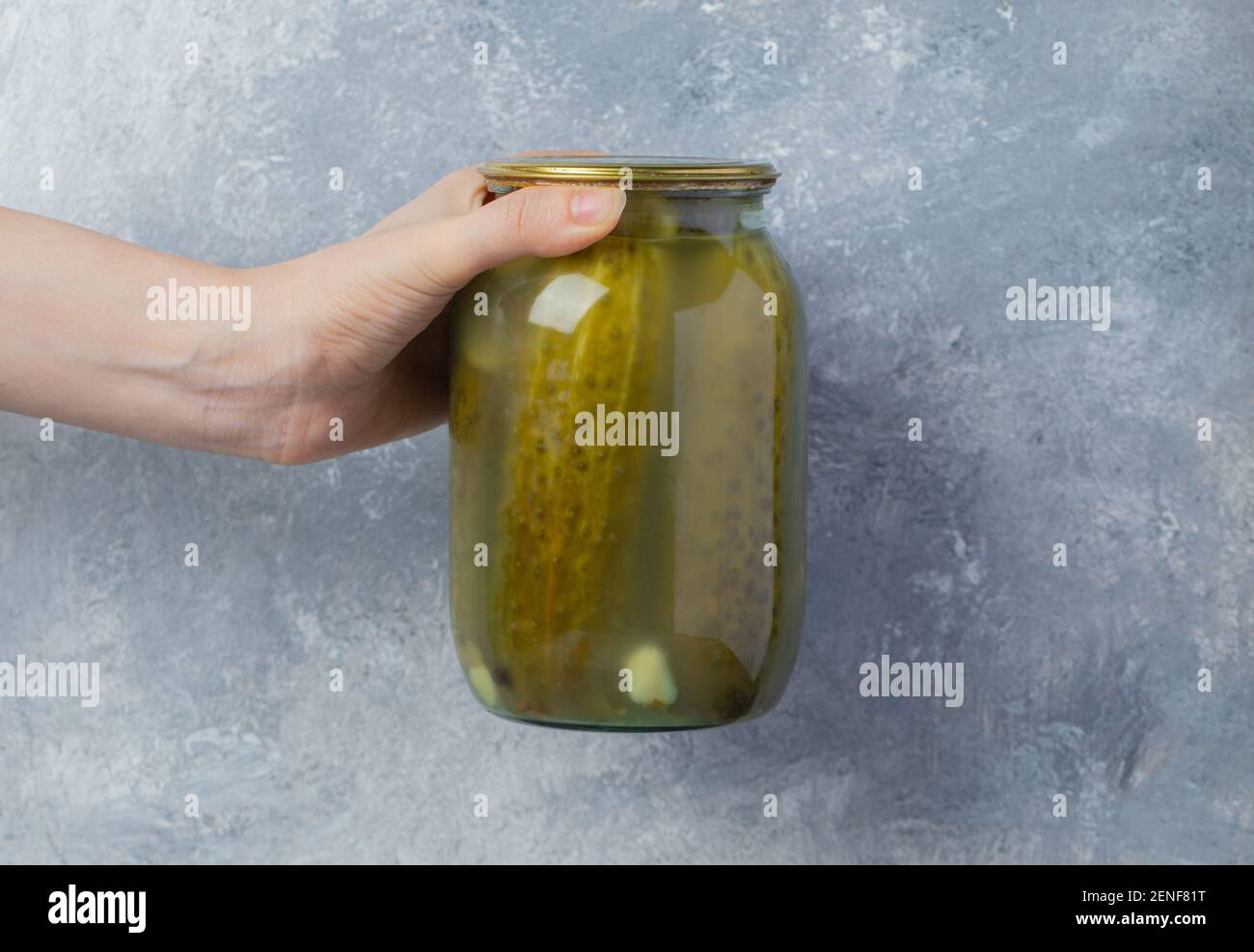 Female hand holding pickle jar in the air Stock Photo - Alamy