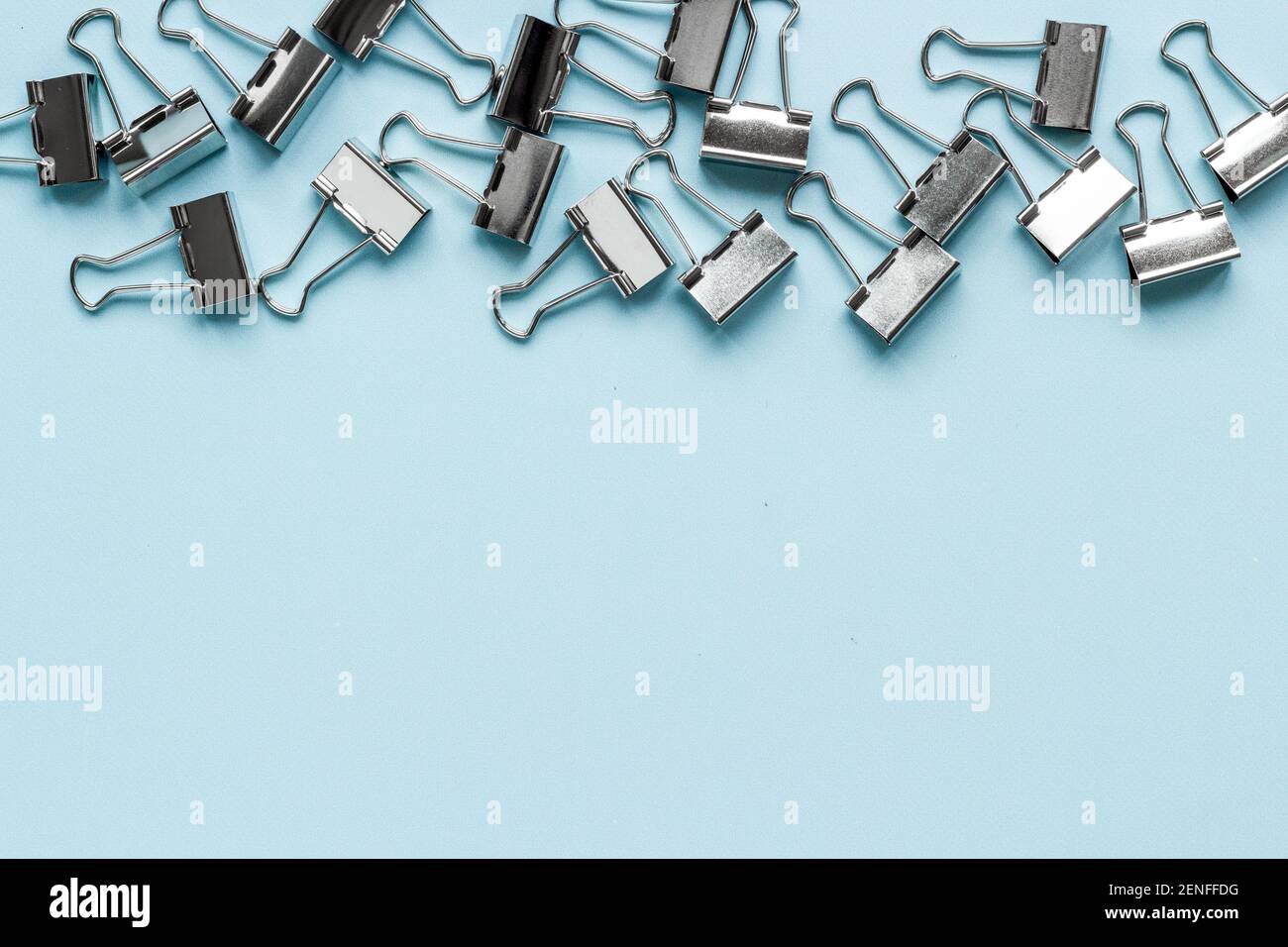 Stationery and office supplies background. Paper binder clips top view ...