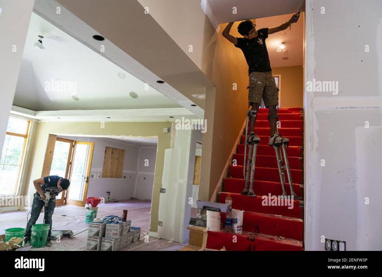 Jonathan Valverde (izq.) y Daniel Gomez de J&E Drywall aplícan una capa ...