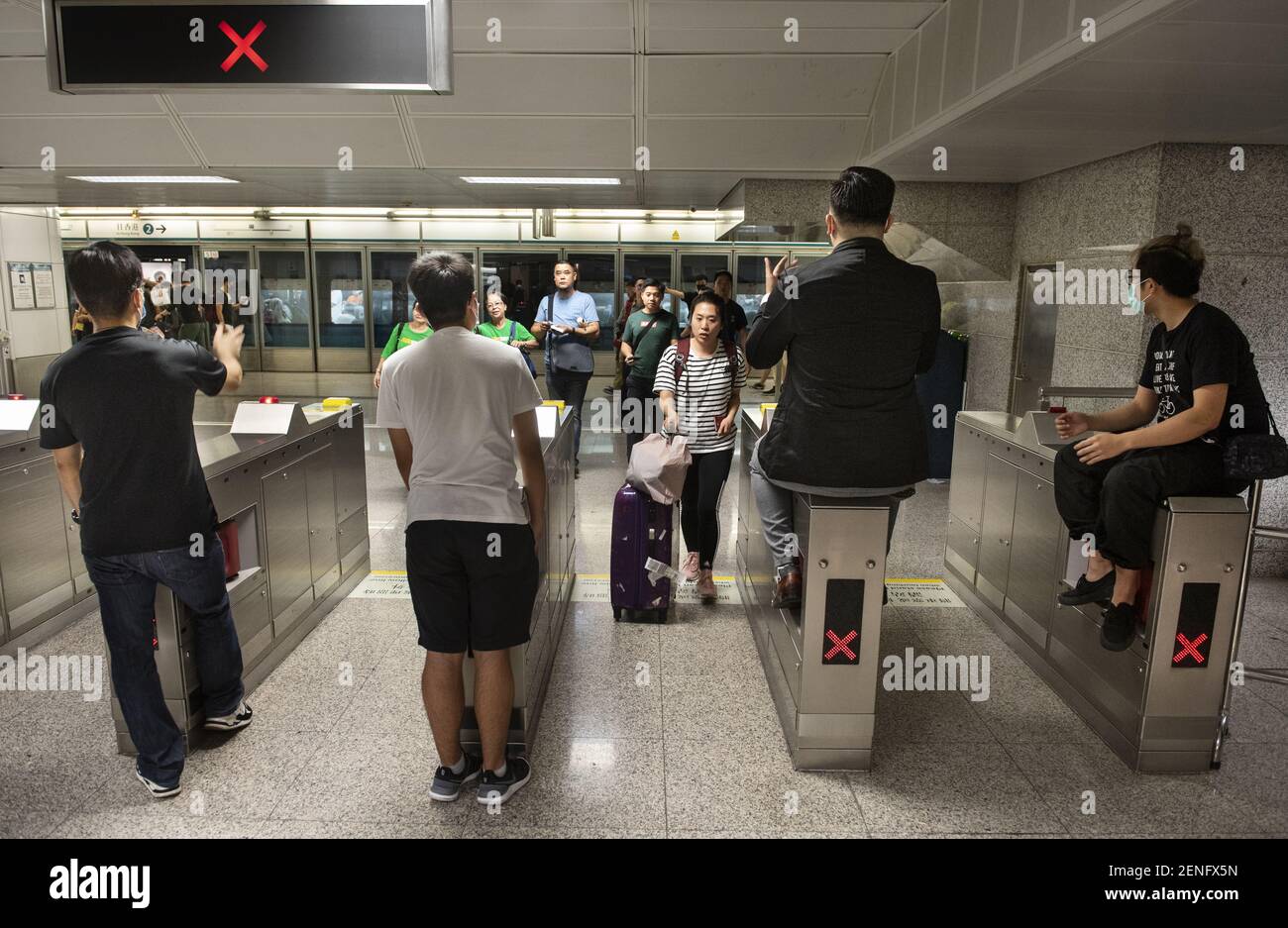 Anti-government protesters let commuters and travellers go inside the ...