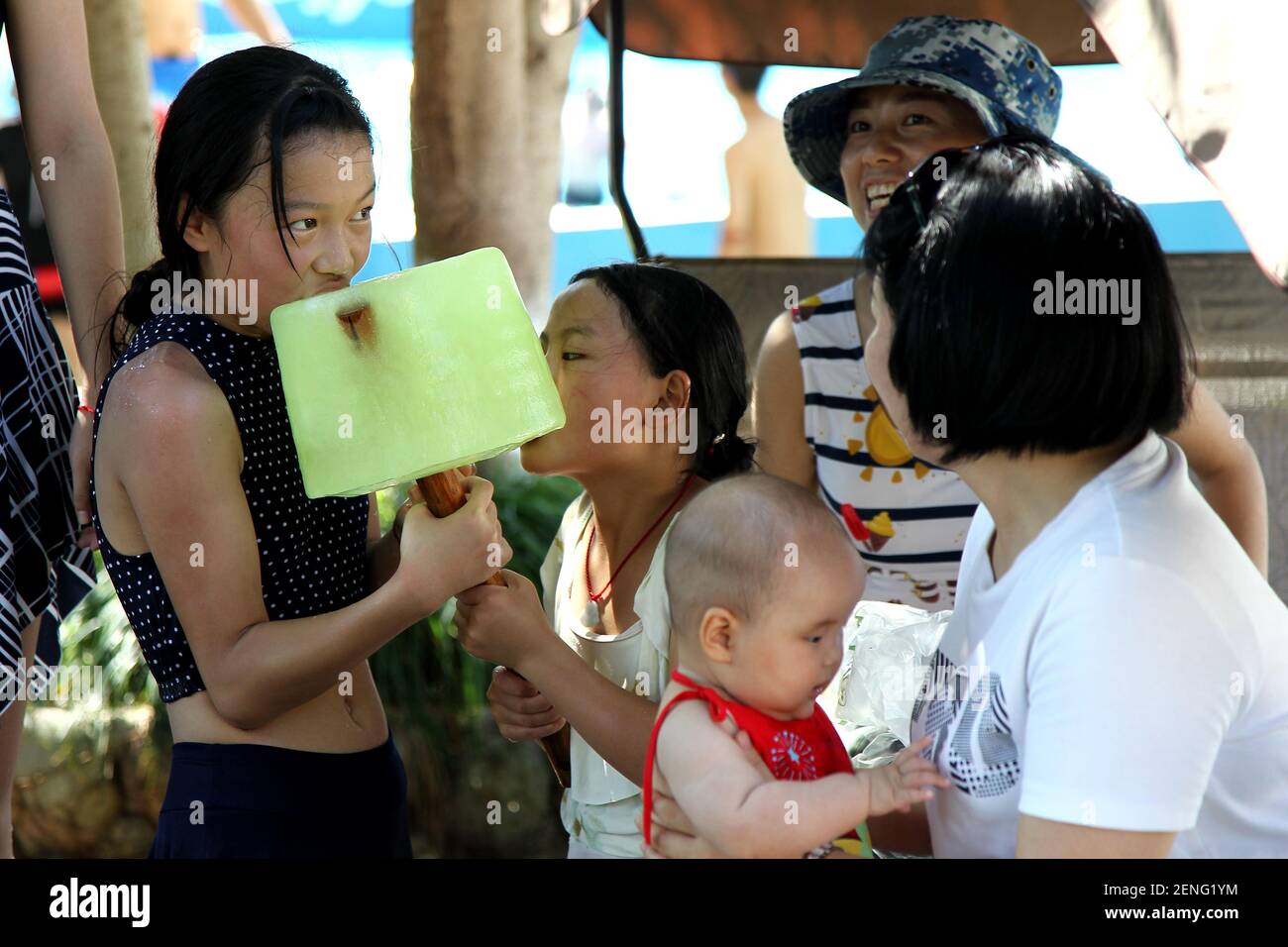 Local residents enjoy huge ice-sucker on a scorching day at a swimming ...