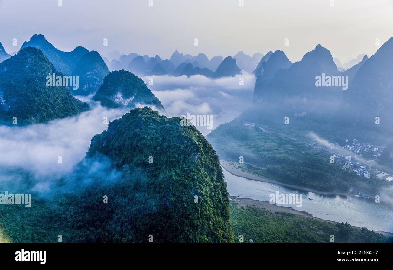 The mountains and hills are surrounded by mist and cloud along the Li ...