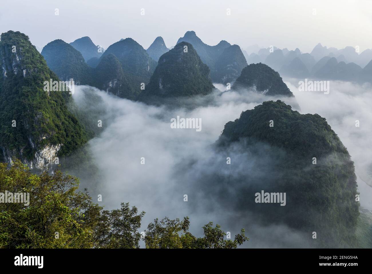 The mountains and hills are surrounded by mist and cloud along the Li ...