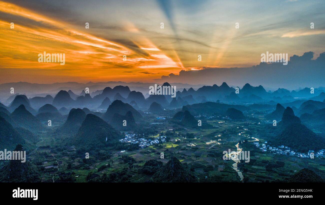 The mountains and hills are surrounded by mist and cloud along the Li ...