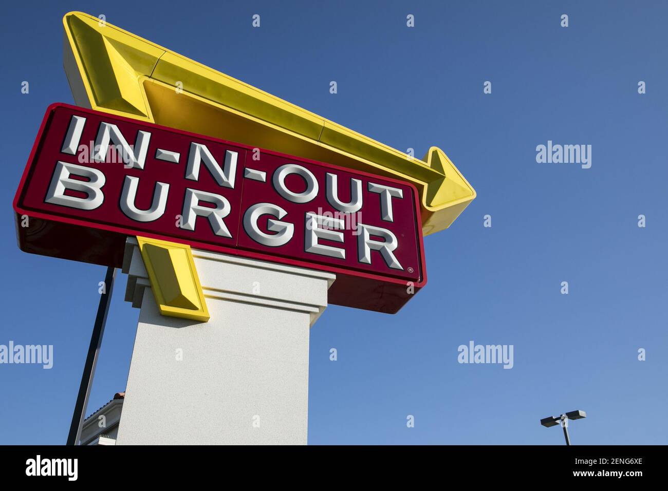 A logo sign outside of a In-N-Out Burger fast food restaurant location ...