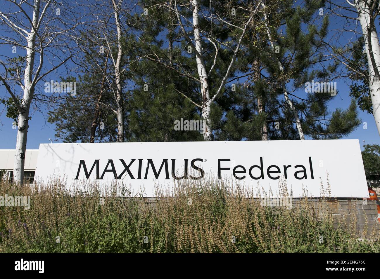 A logo sign outside of a facility occupied by MAXIMUS Federal in Sandy ...