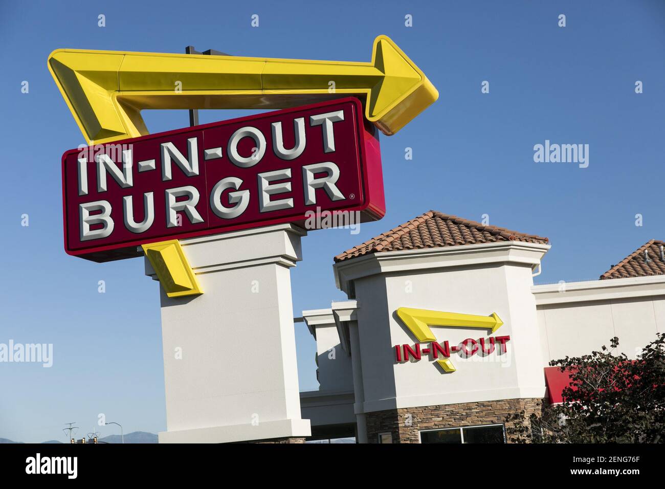 A logo sign outside of a In-N-Out Burger fast food restaurant location ...