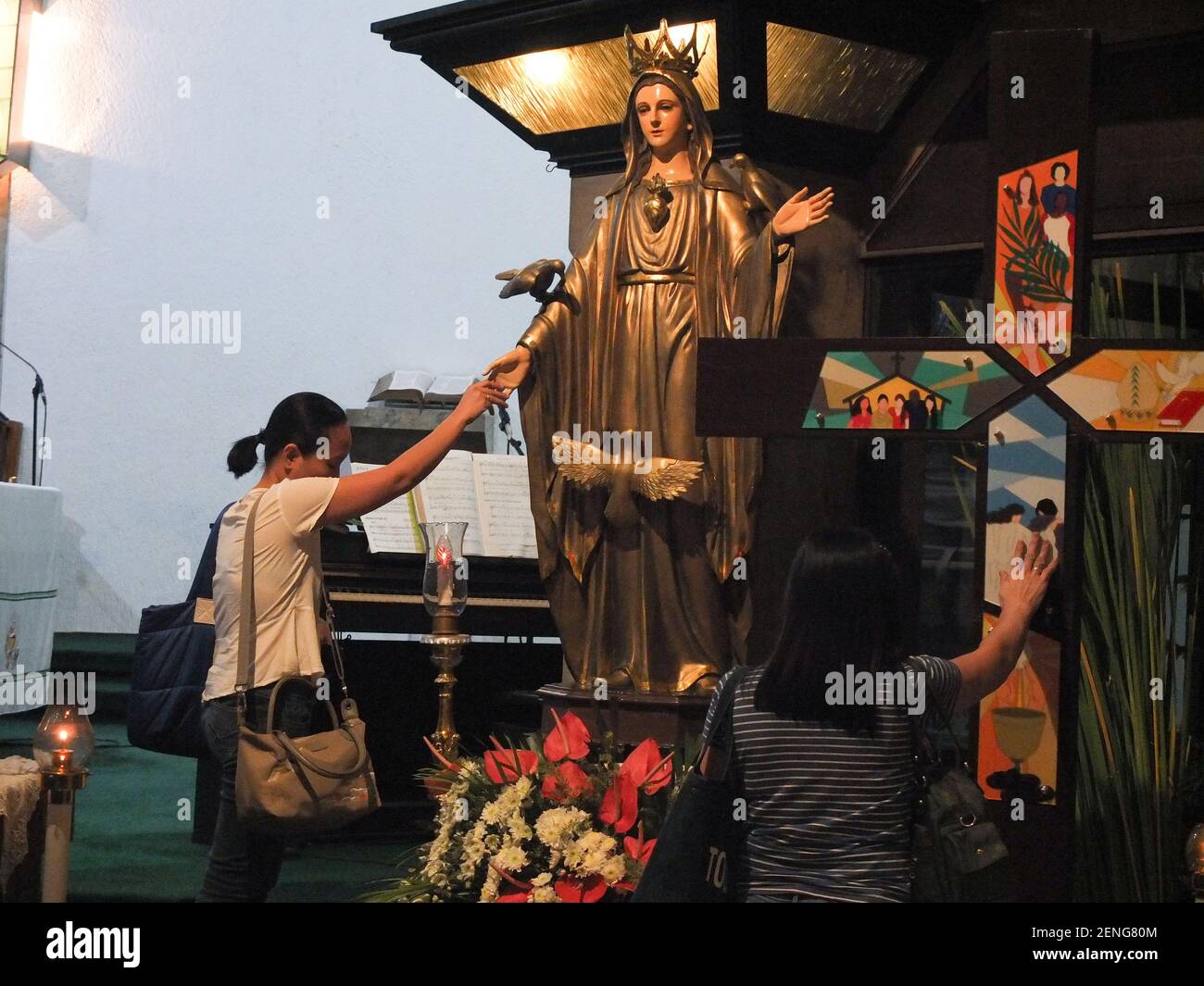 Women devotees touch the hand of Mary, Queen of Peace Statue and the ...