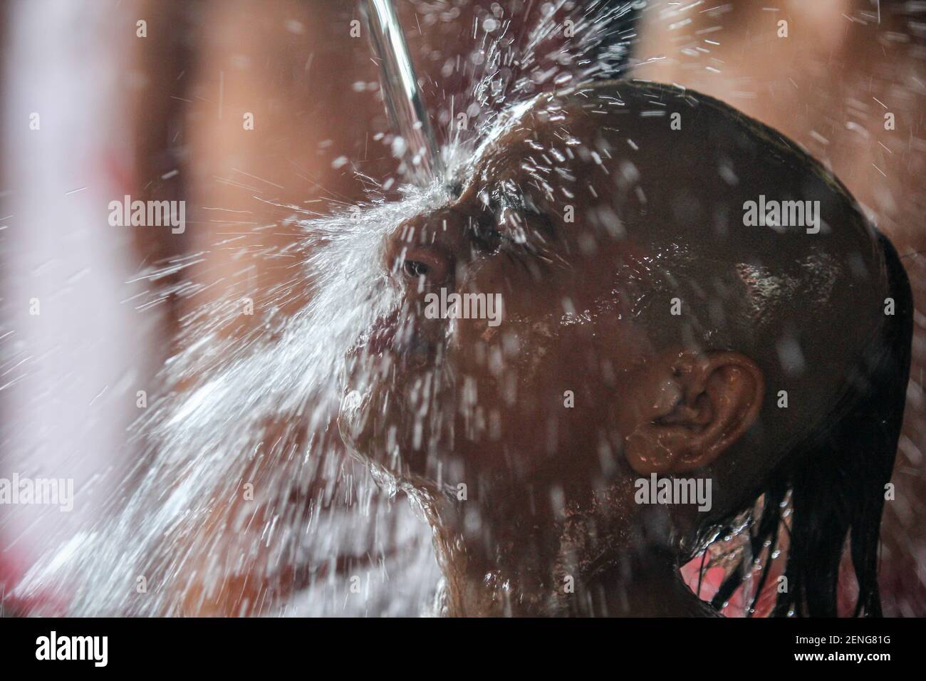 A young Hindu priest takes a holy bath during the festival. The Janai ...