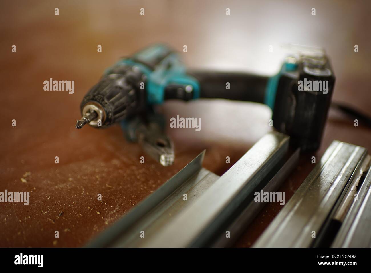 A drill and new drywall profiles lies on a brown floor Stock Photo - Alamy