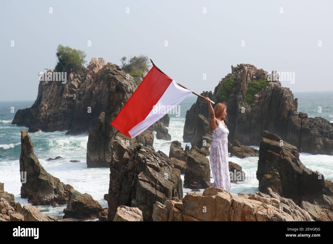 An Indonesian woman seen carrying the Indonesian flag, on the rock of ...
