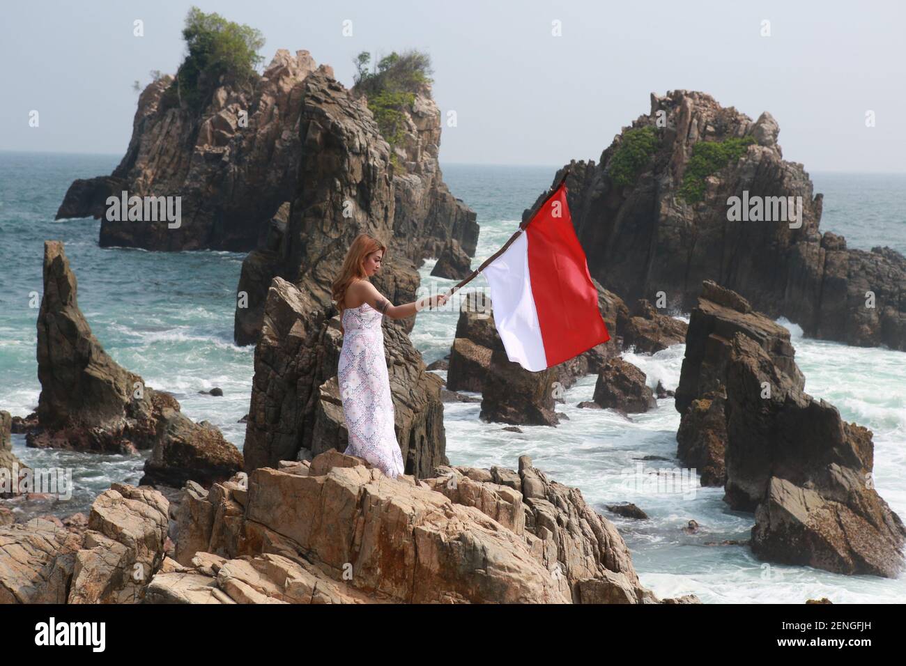 An Indonesian woman seen carrying the Indonesian flag, on the rock of ...