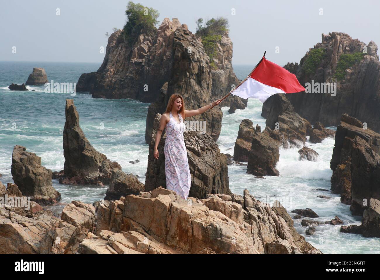 An Indonesian woman seen carrying the Indonesian flag, on the rock of ...