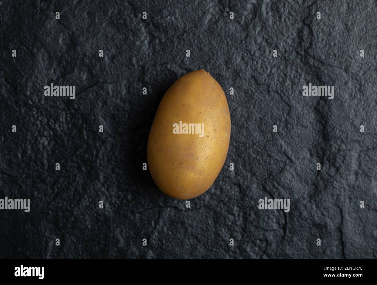 Top view of single potato on black background Stock Photo - Alamy