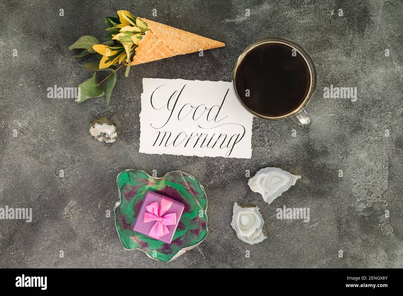 Gift box on resin art plate, paper card and coffee mug on gray ...