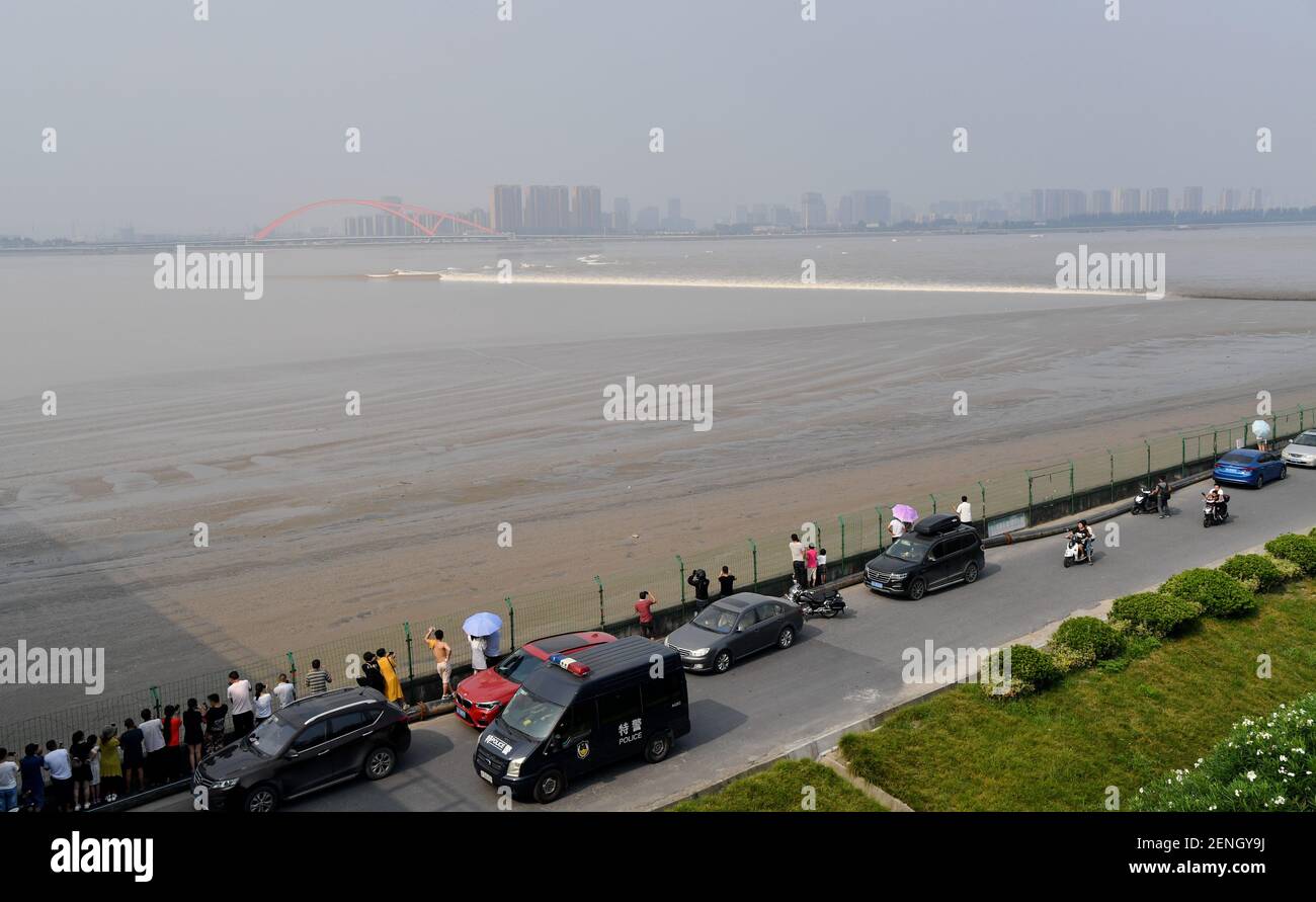 Visitors and local residents watch the tidal bore of the Qiantang River ...