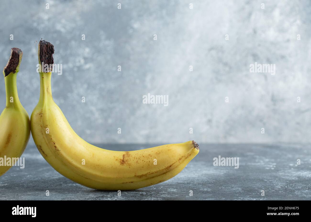 Two ripe bananas over grey background Stock Photo - Alamy