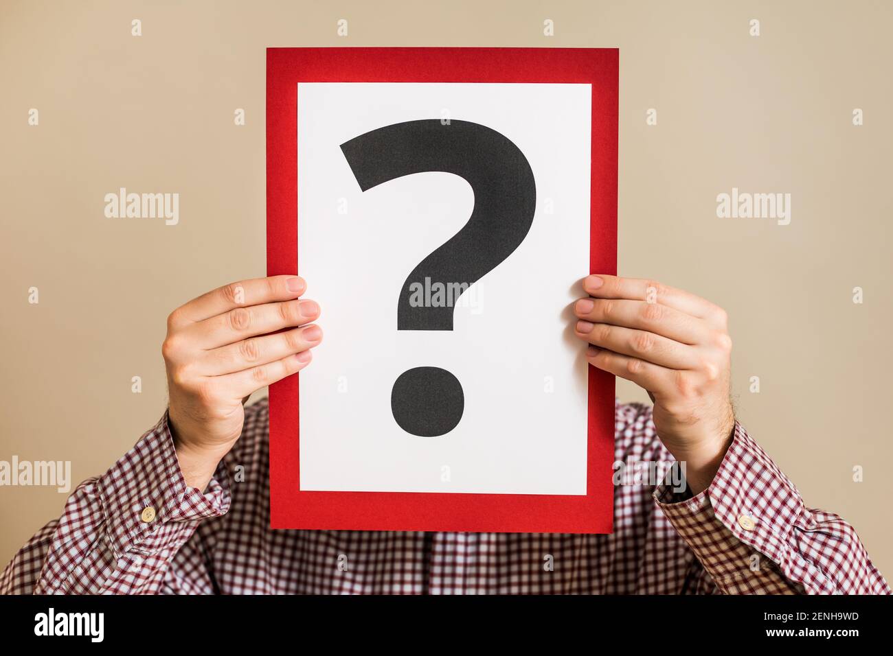 Confused man holding paper with question mark Stock Photo - Alamy