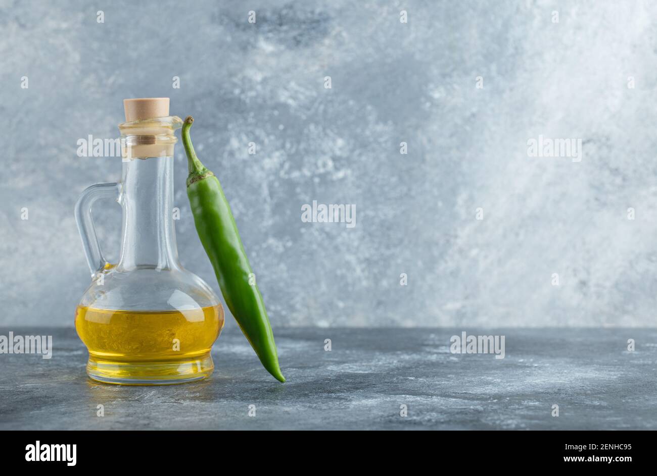 Green hot pepper with bottle of oil on grey background Stock Photo - Alamy
