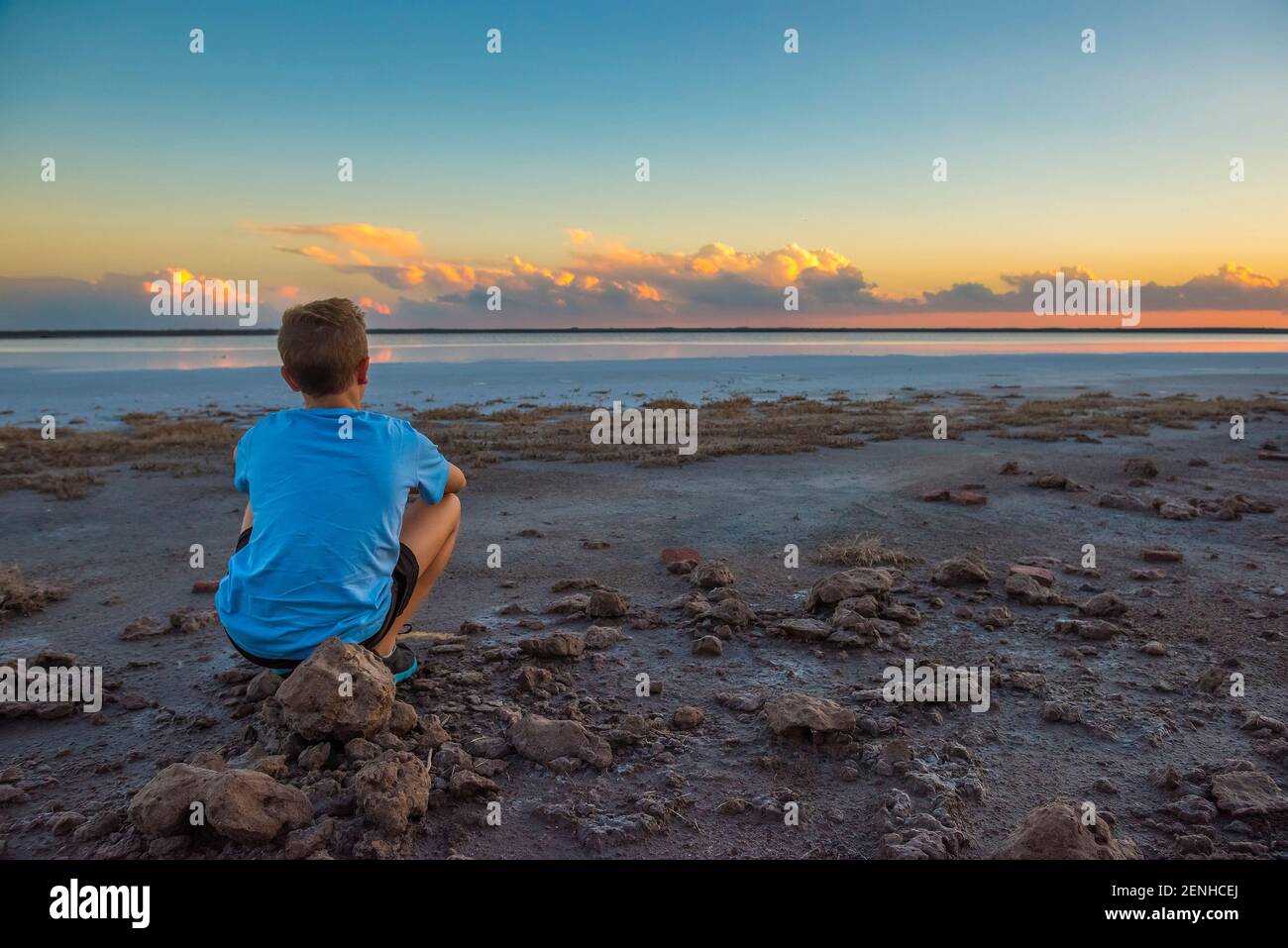 Boy looking at the horizon at sunset Stock Photo - Alamy