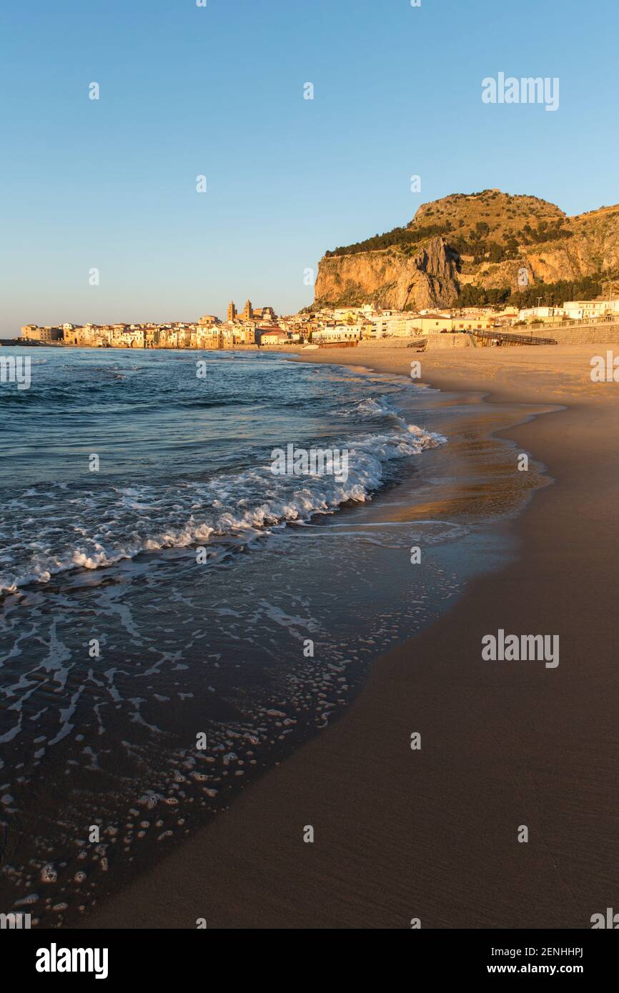 Italy,Sicily,Cefalu, the beach and surf with Cefalu and Rocca in the ...