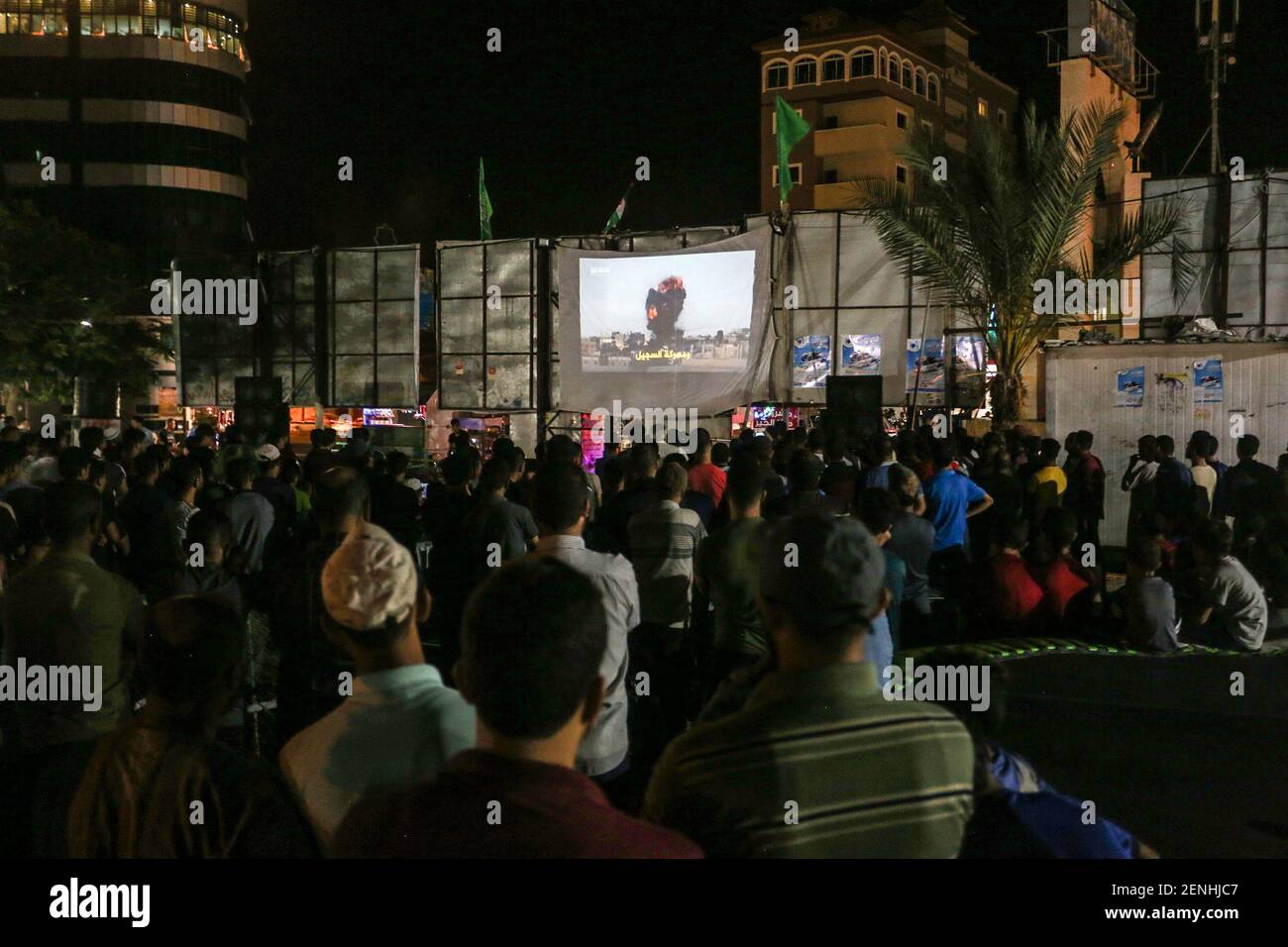 Palestinians watch video on a large screen, the fifth anniversary of ...
