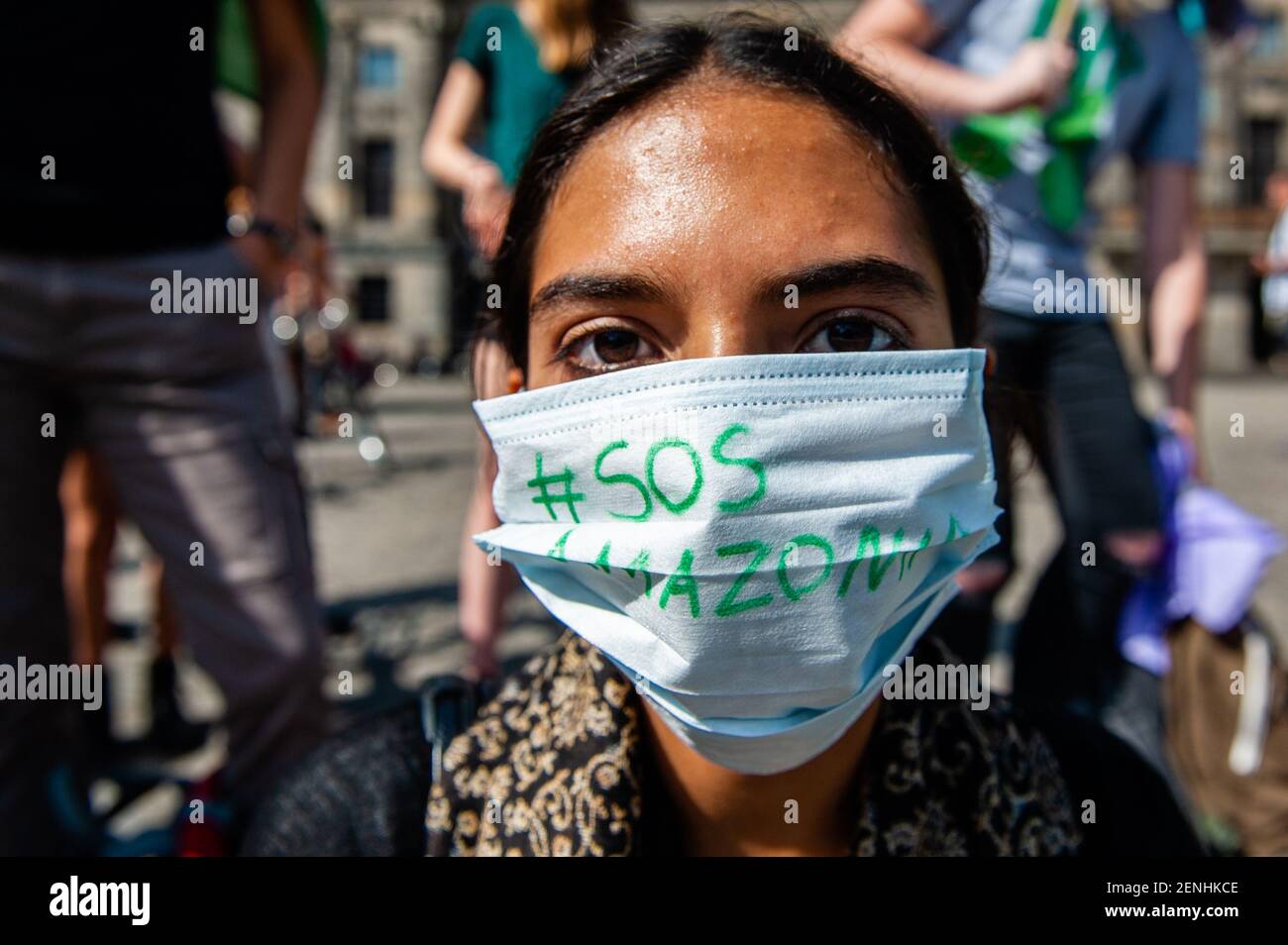 A woman wearing a dust mask that says SOS Amazon takes part during the ...