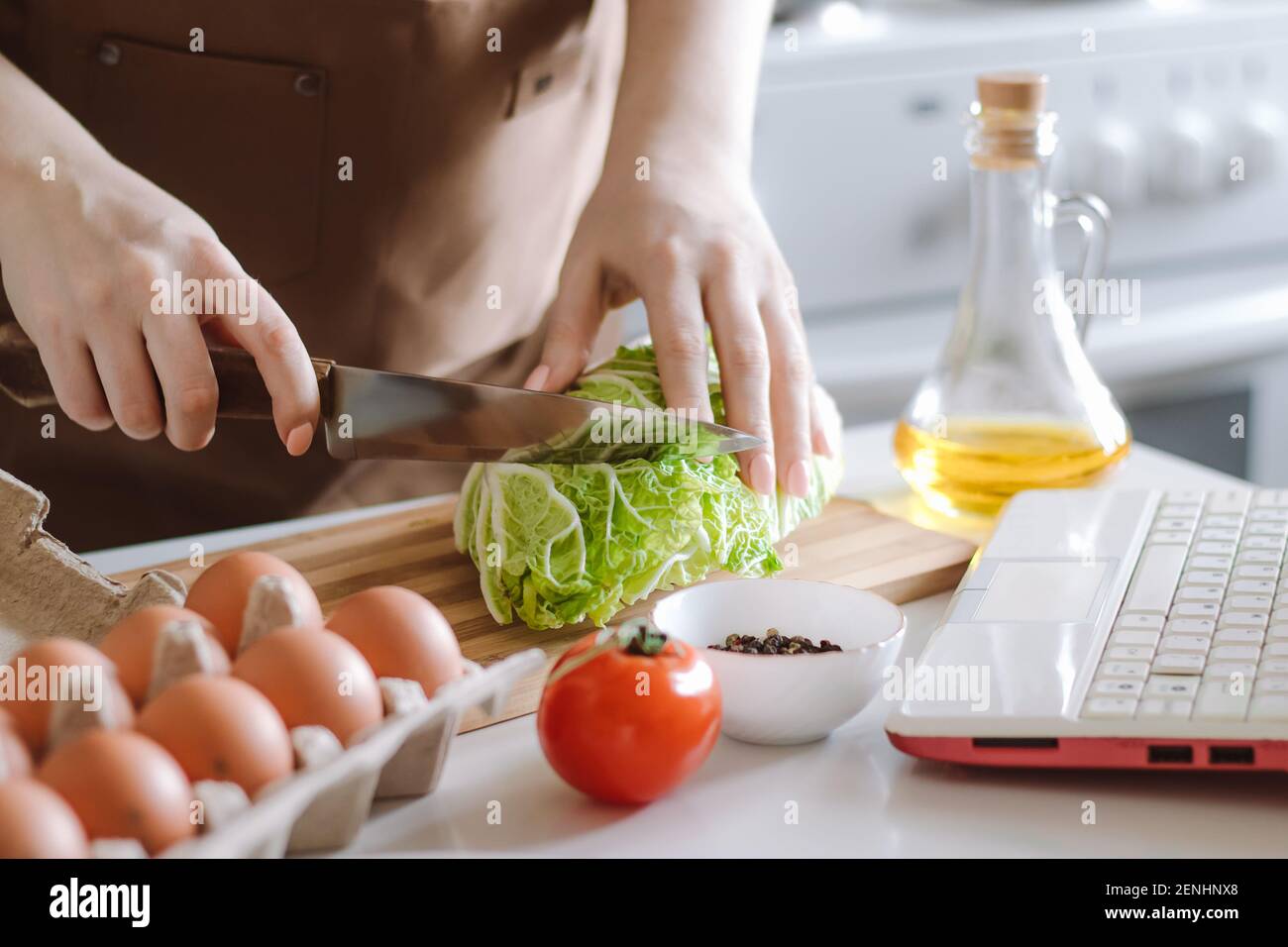 Woman prepares dietary vegetable salad at home using video recipe ...