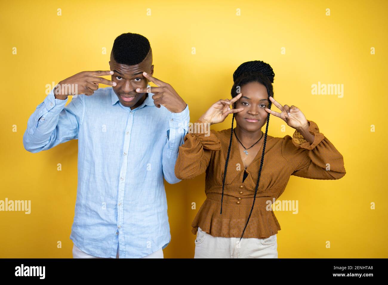 Doing peace symbol with fingers over face, smiling cheerful showing ...