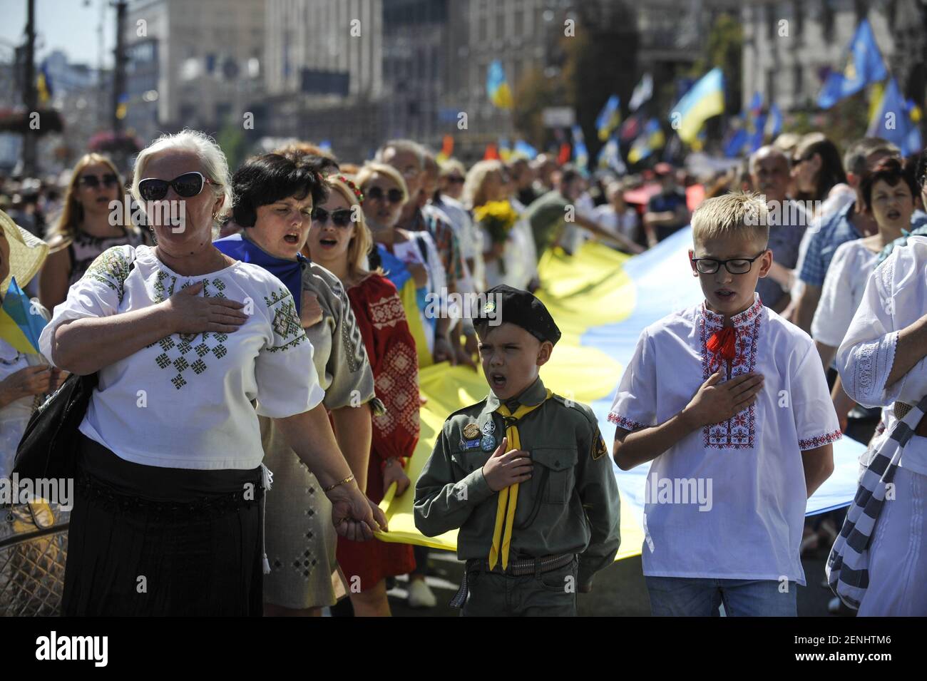 Ukrainians sing the Ukrainian anthem during the March of defenders to ...