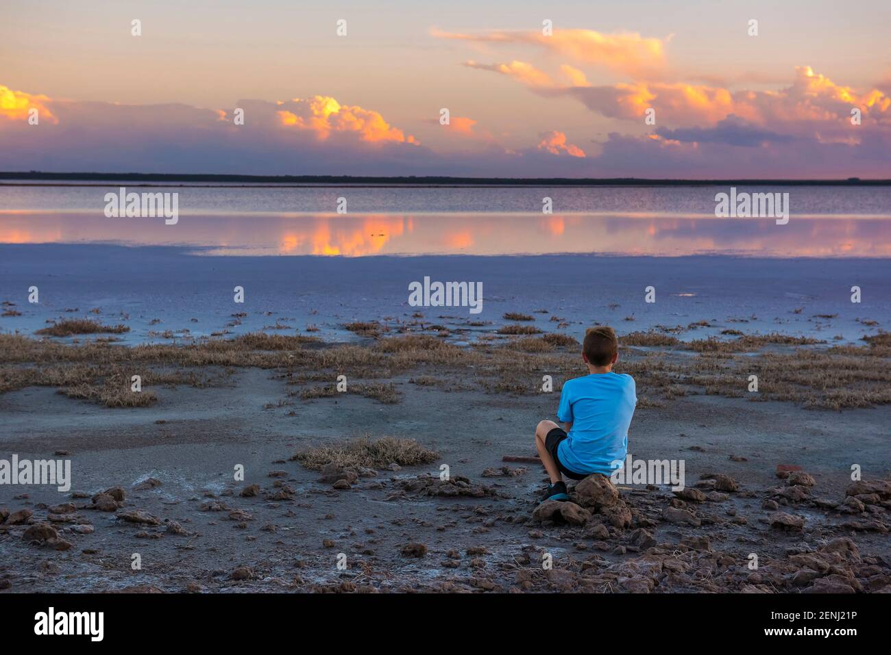 Boy looking at the horizon at sunset Stock Photo - Alamy