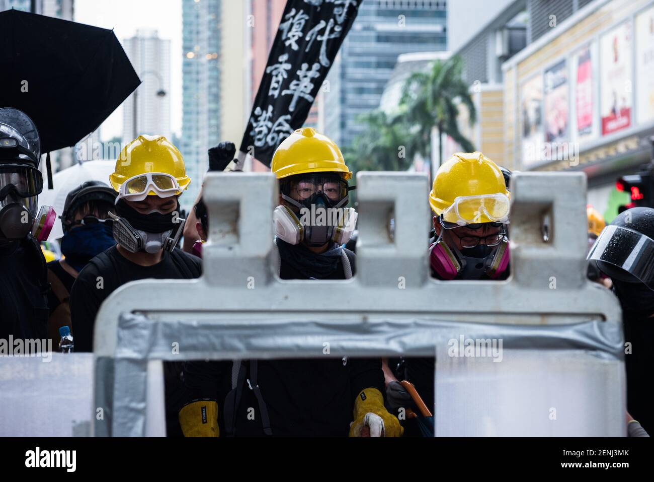 Protesters gaze at riot police from behind a barricade during the ...