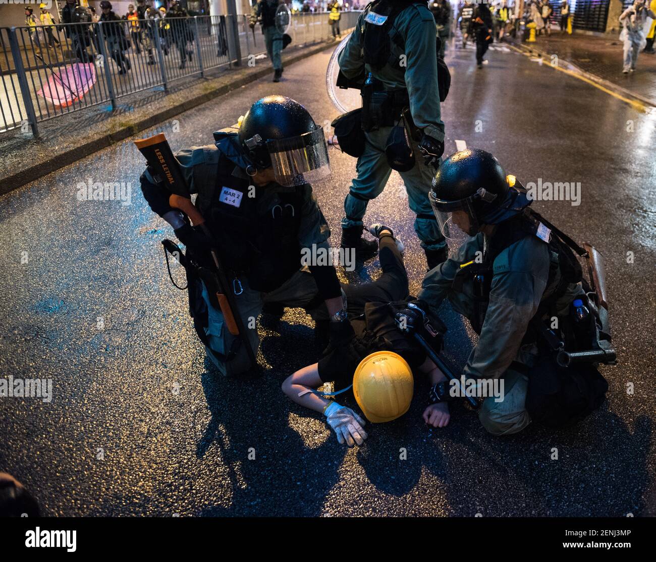 Riot police officers wrestle a protester to the ground during the ...