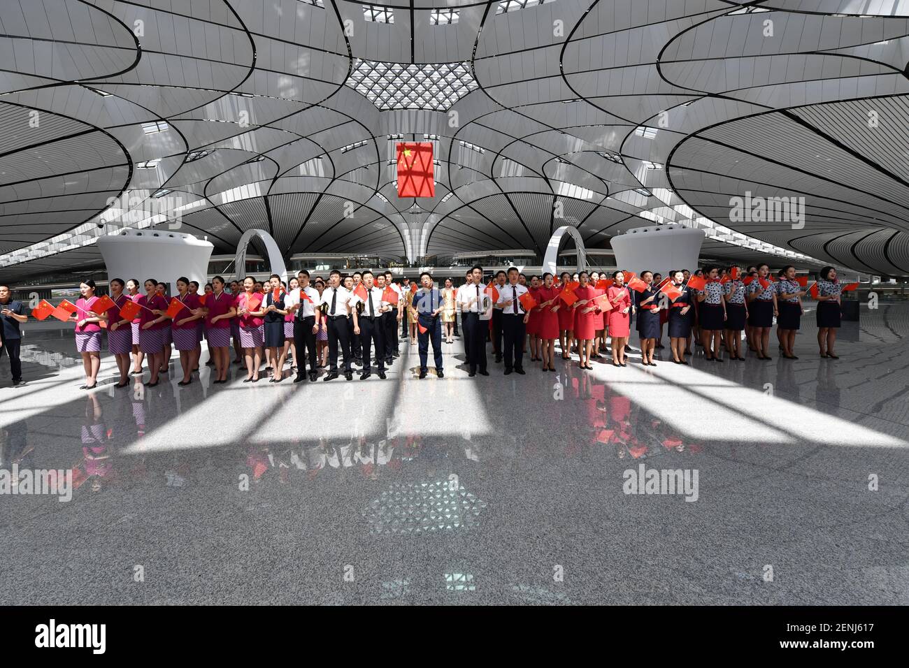 Chinese crew members hold national flags and sing at the Beijing Daxing ...