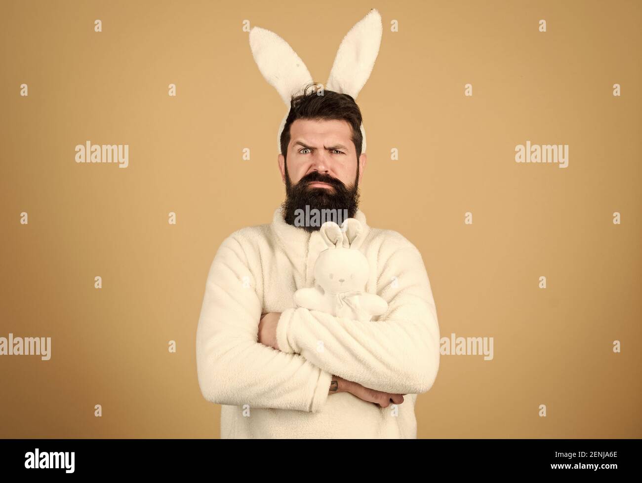 Guy bearded hipster weird bunny with long white ears beige background ...