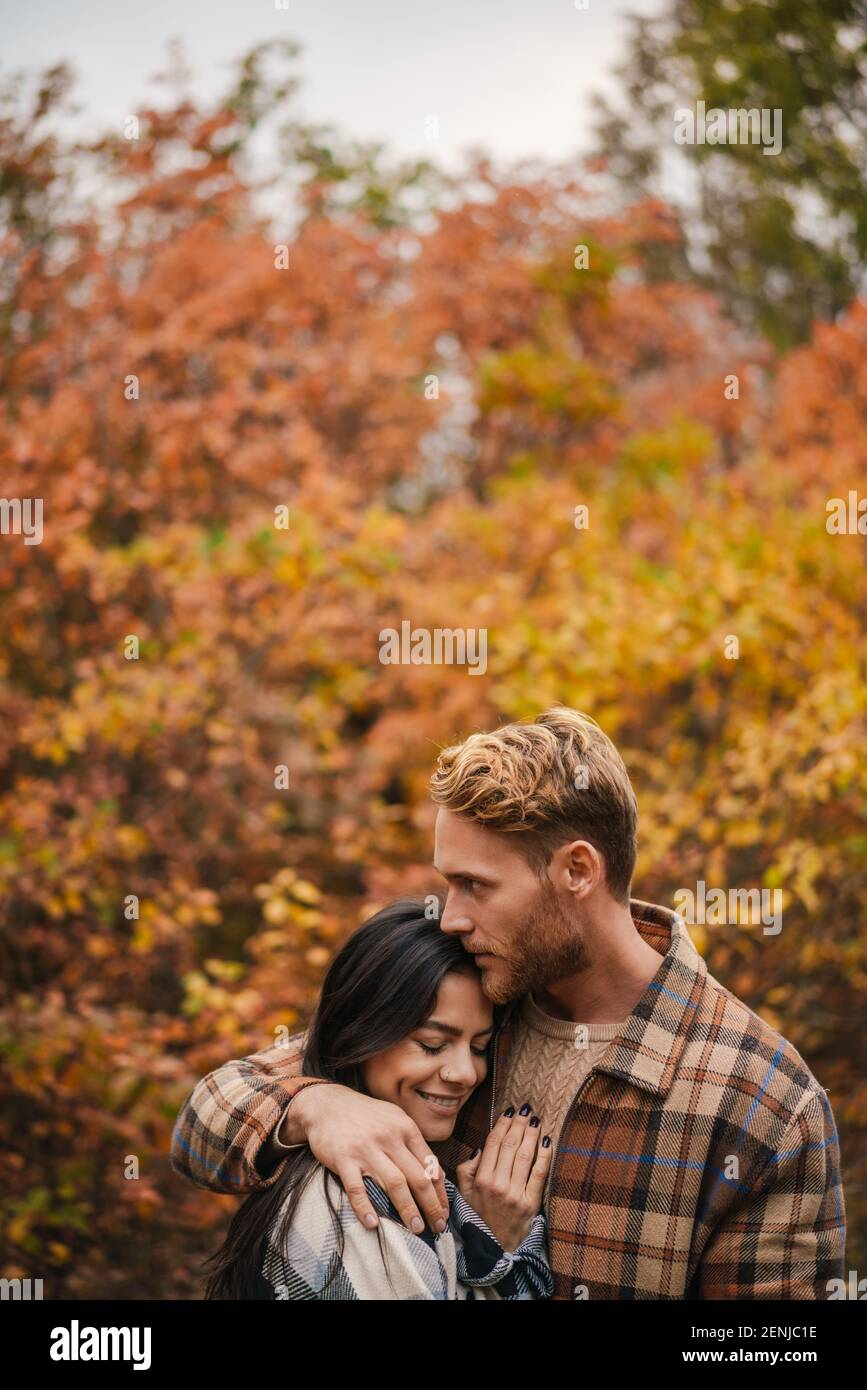 Beautiful happy romantic couple hugging while strolling in autumn ...