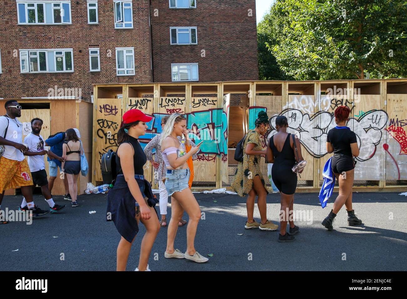 People attend the Notting Hill Carnival in West London are seen using ...