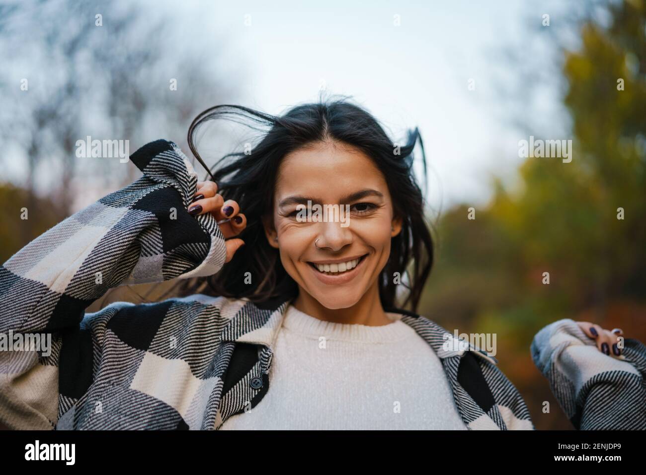 Beautiful brunette happy woman smiling while strolling in autumn forest ...