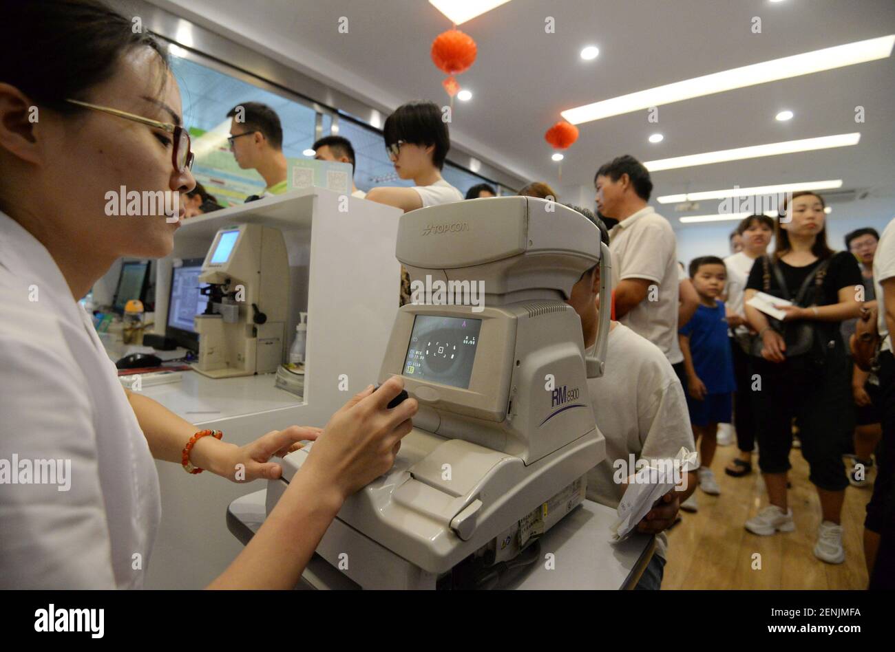 A Chinese doctor examines the eyesight of a young myopic kid at an ...