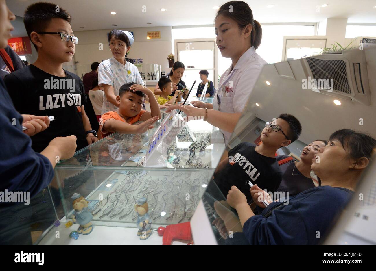 A young myopic boy tries out a new pair of near-sighted glasses at an ...