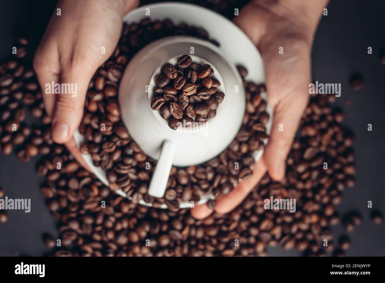 coffee beans white saucer and an inverted cup close-up dark background ...