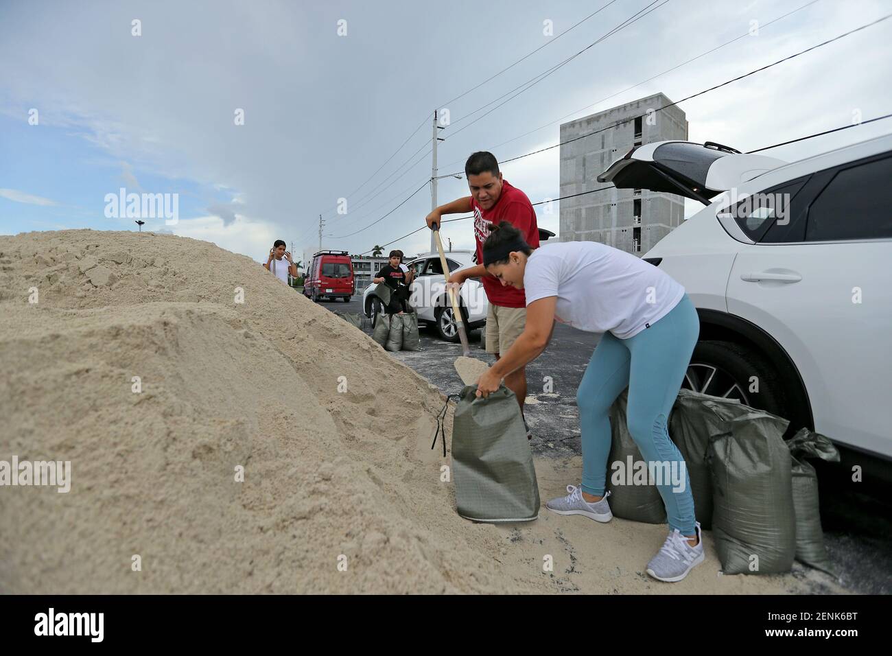 Farah and Max Cicardini fill sand bags at the parking of the Big Easy ...