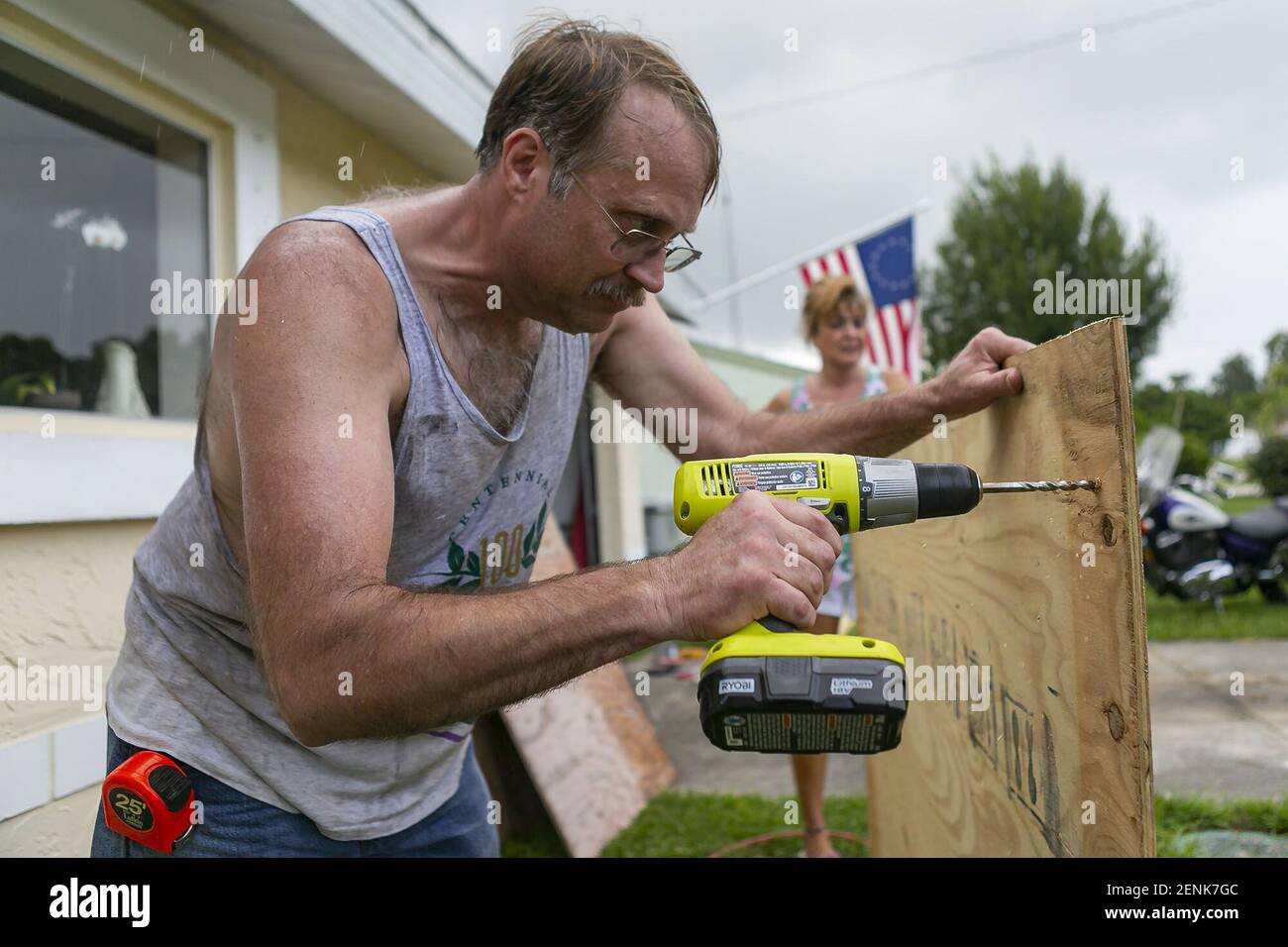 Colin Johnson, 51, drills plywood as he prepares to board a window of ...